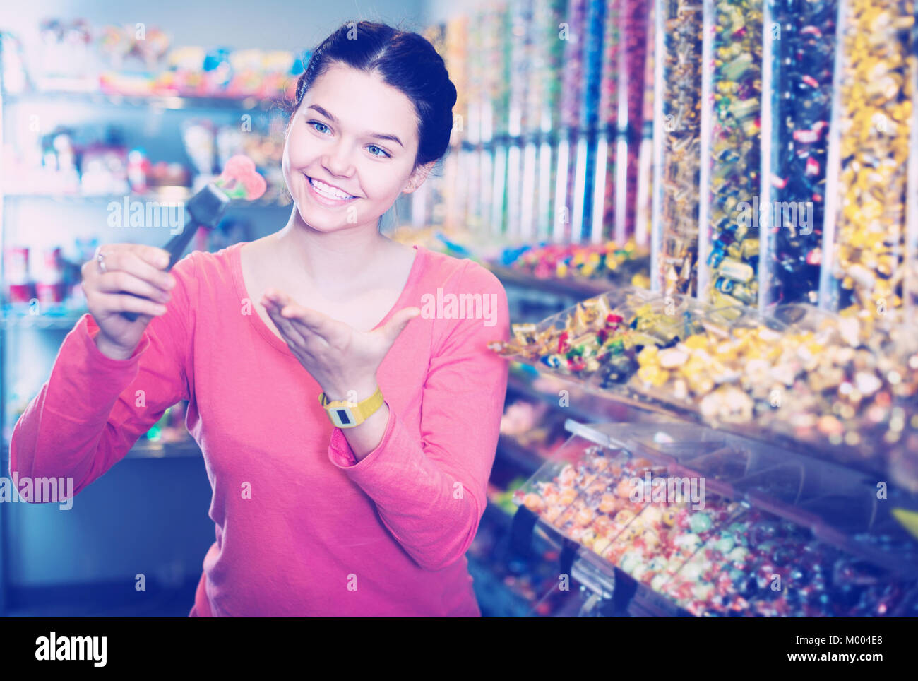 Portrait of young cheerful woman with candies at sweets shop Stock ...