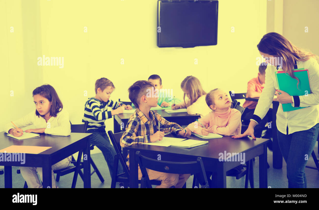 Professor and elementary age children at classroom Stock Photo - Alamy