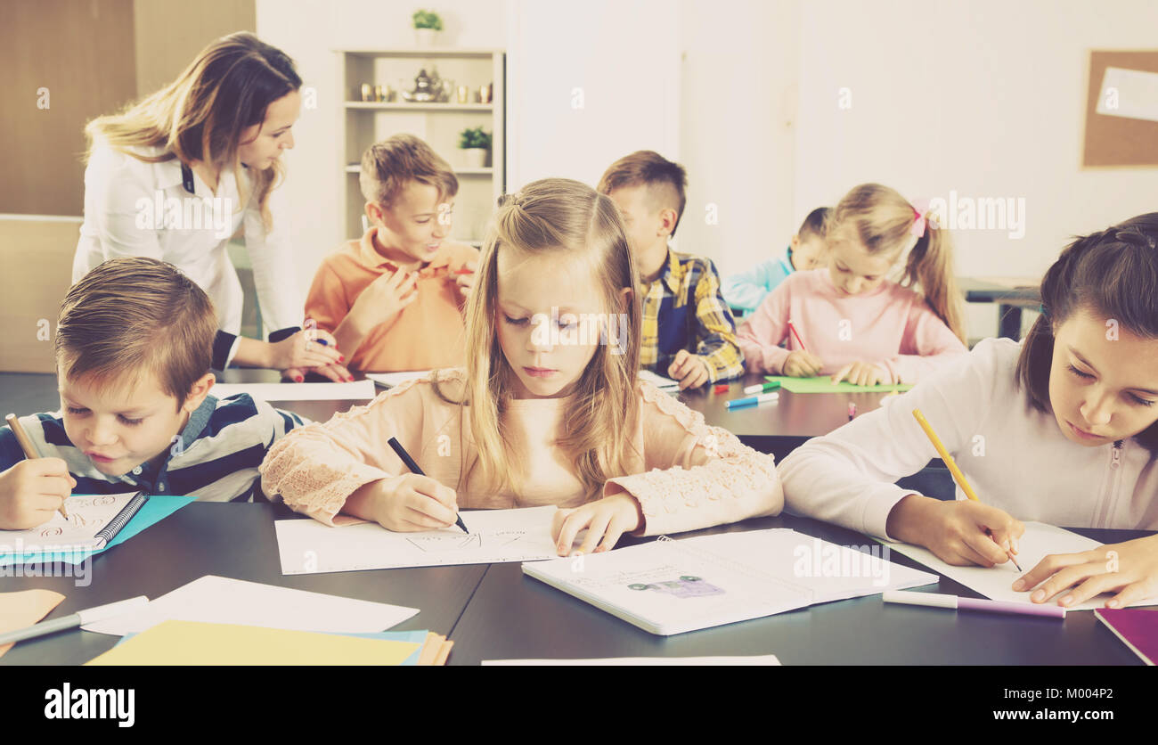 Professor and elementary age children in the classroom at a school ...