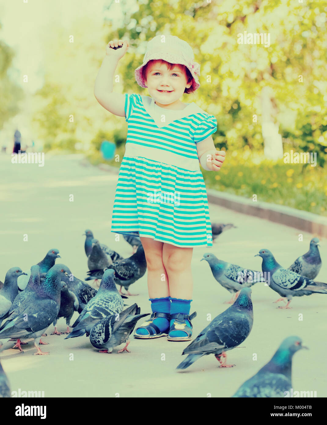 two-year girl with doves in the city street Stock Photo - Alamy