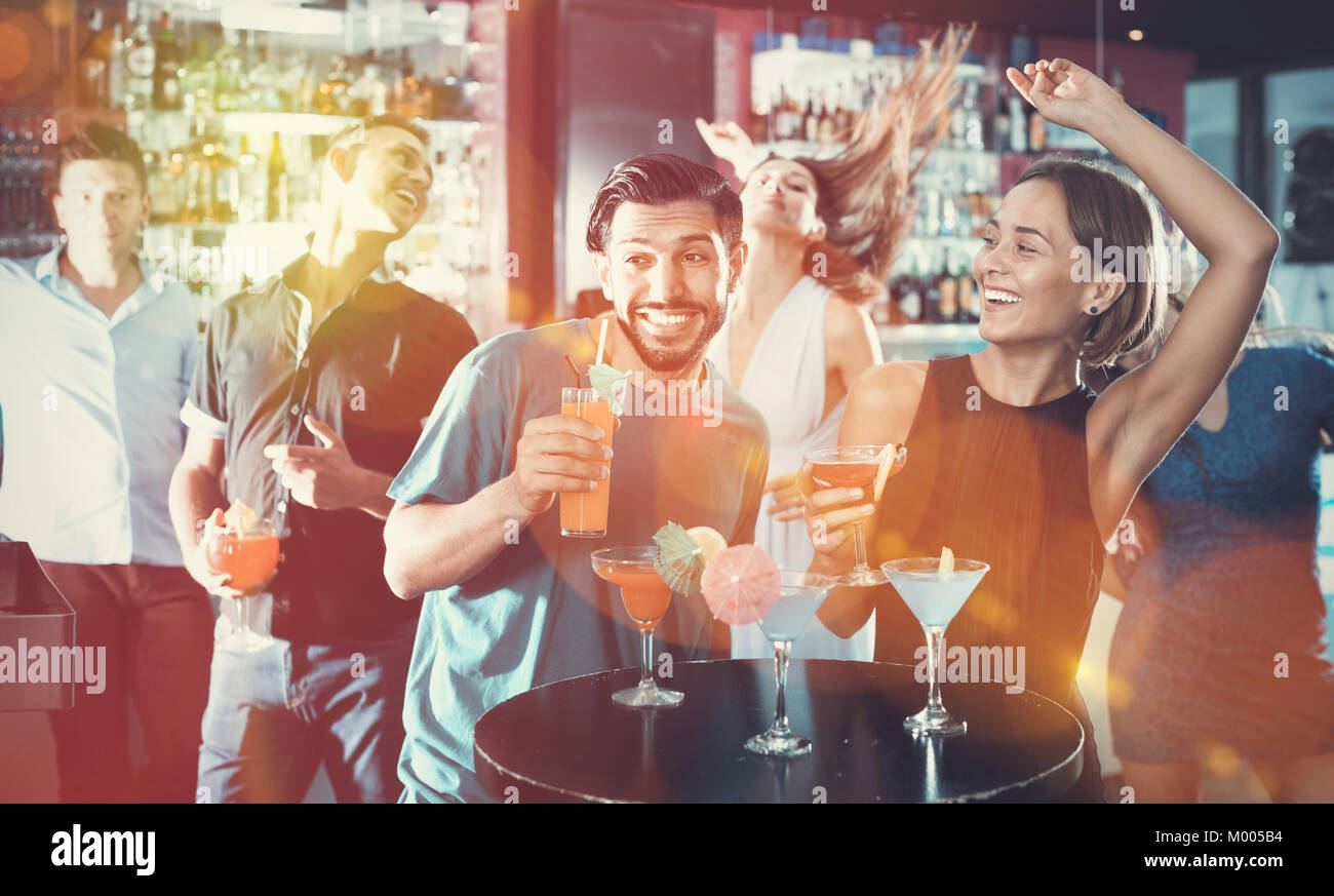 Glad positive man with woman are drinking cocktails on corporate party ...