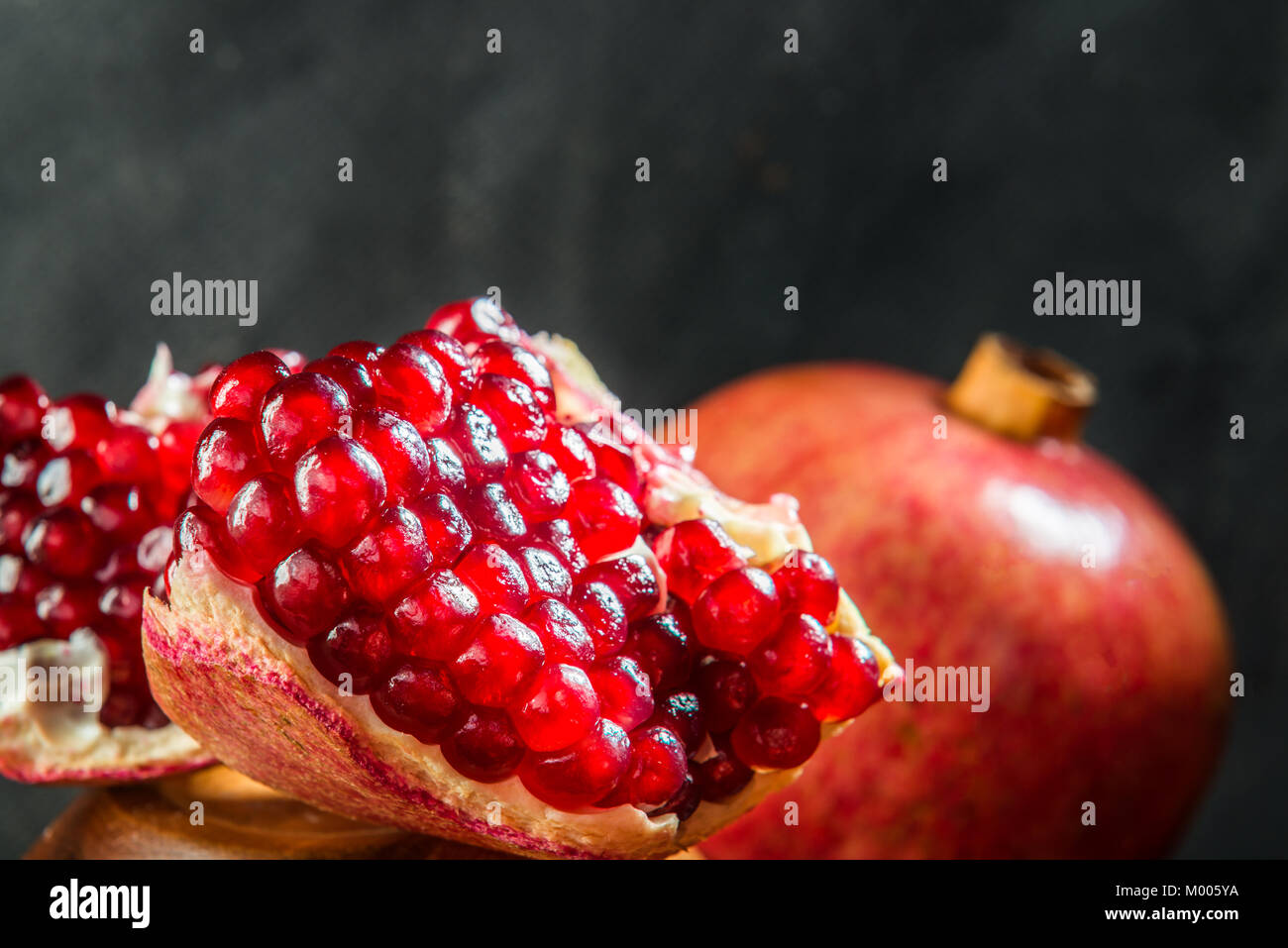 Ripe Open Pomegranates on dark rustic background Stock Photo - Alamy