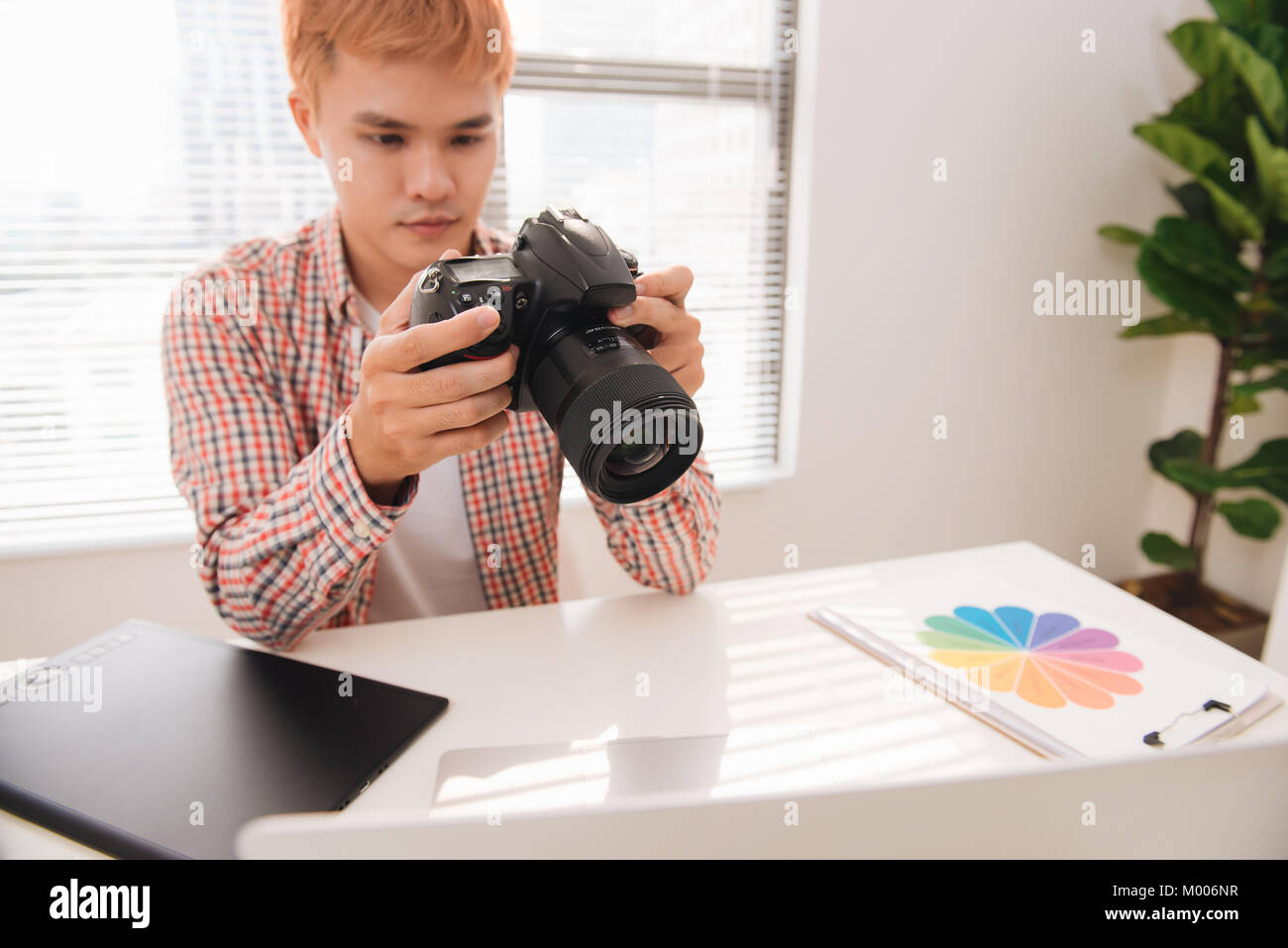 Photographer working at desk in modern office Stock Photo - Alamy