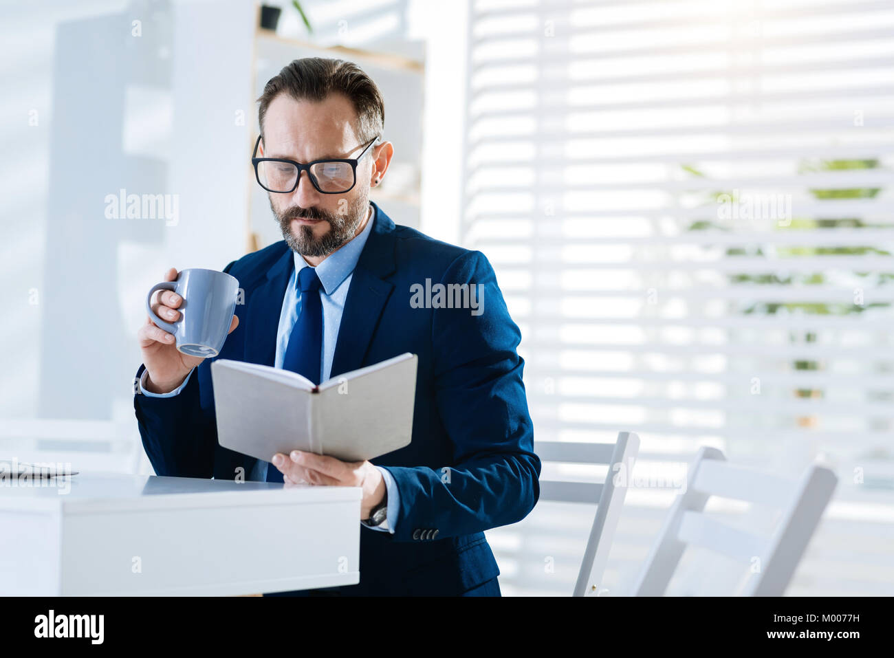 Serious attractive man reading book Stock Photo - Alamy