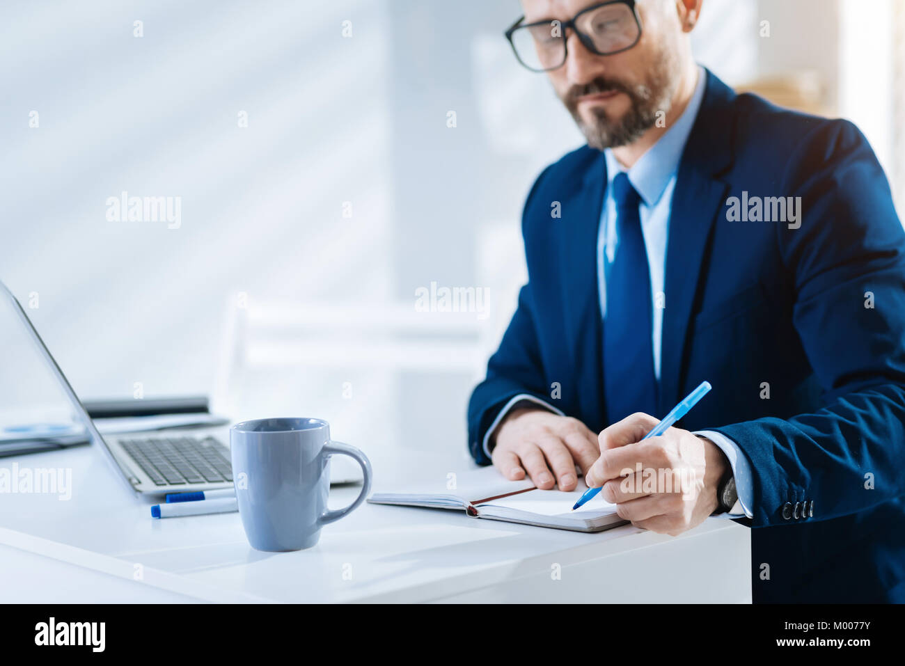 Focused attractive man noting main points Stock Photo - Alamy