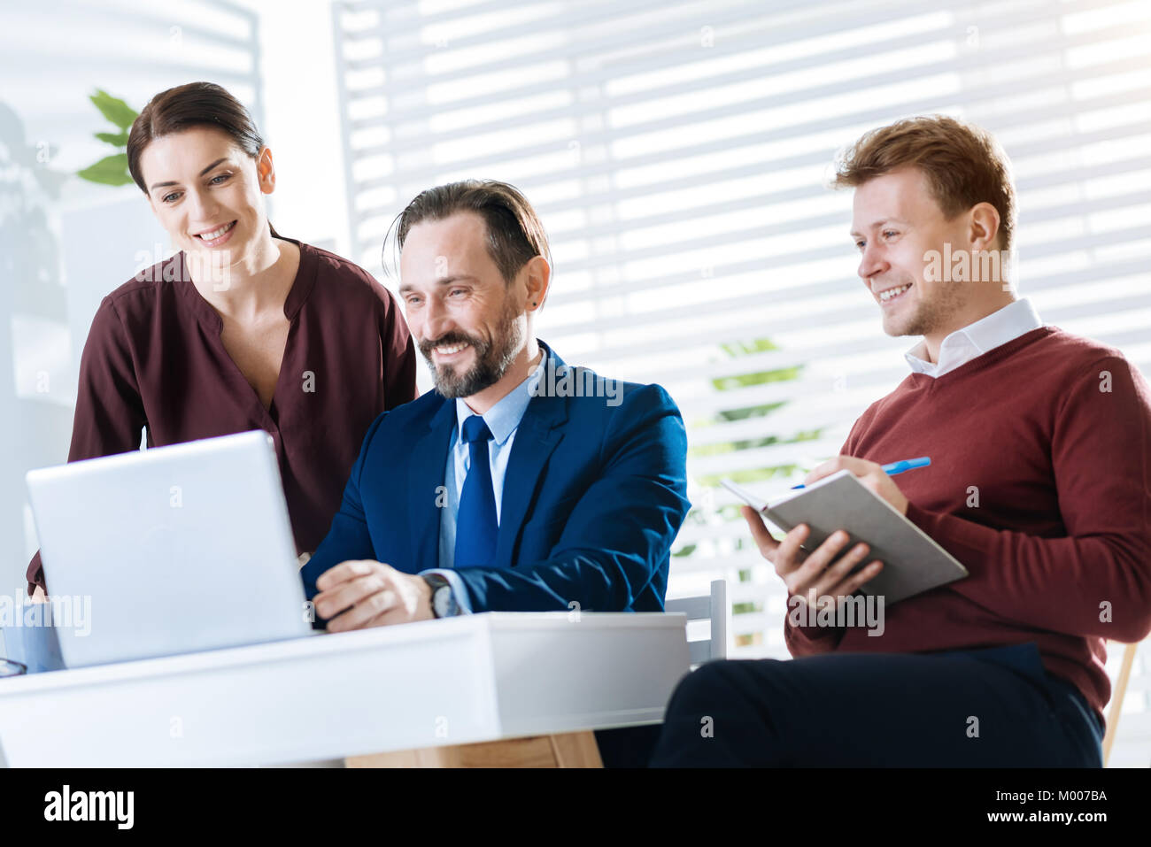 Glad three colleagues planning project Stock Photo - Alamy