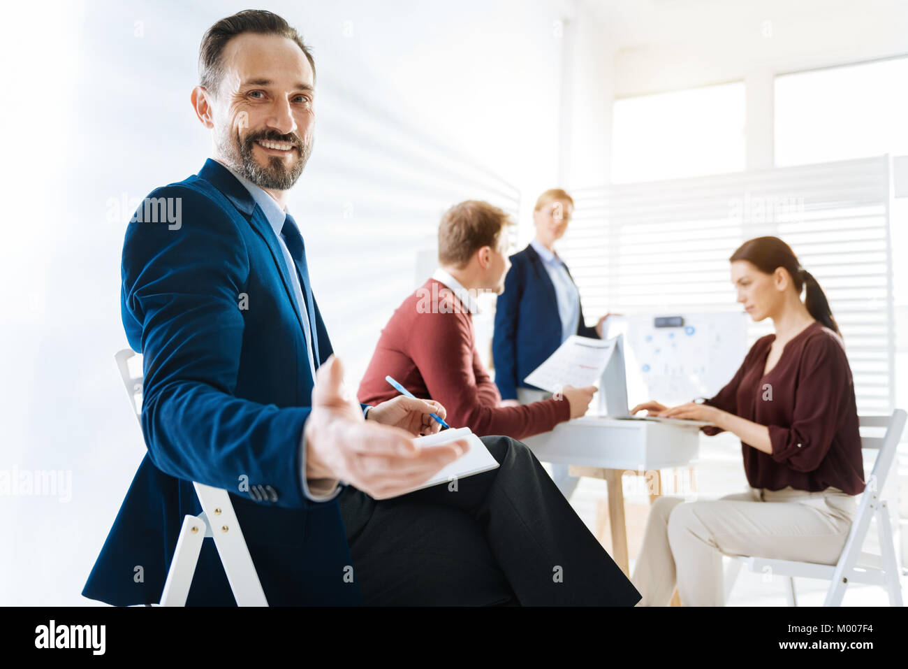 Confident male colleague asking question Stock Photo - Alamy