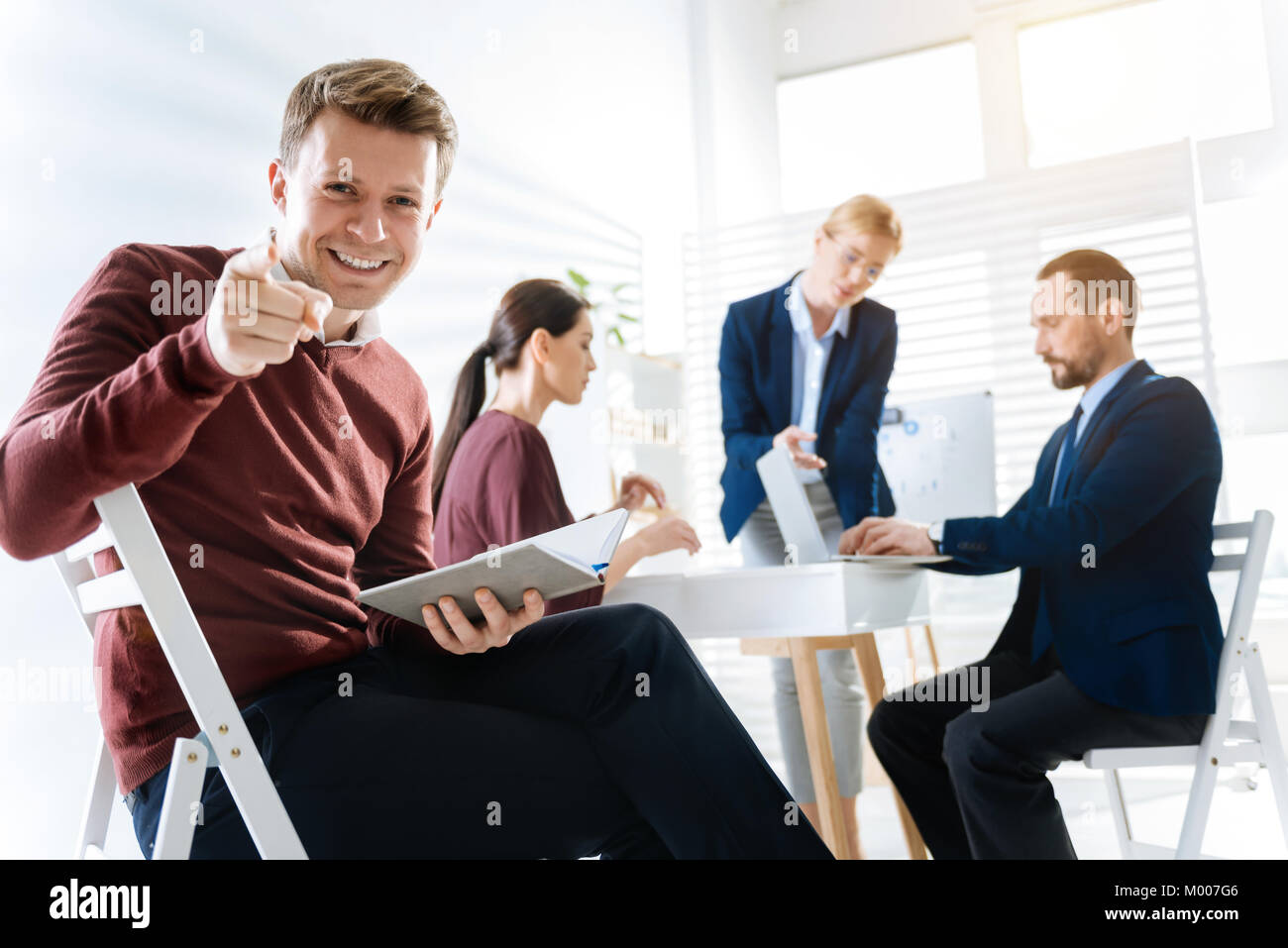 Creative male colleague laughing at joke Stock Photo - Alamy