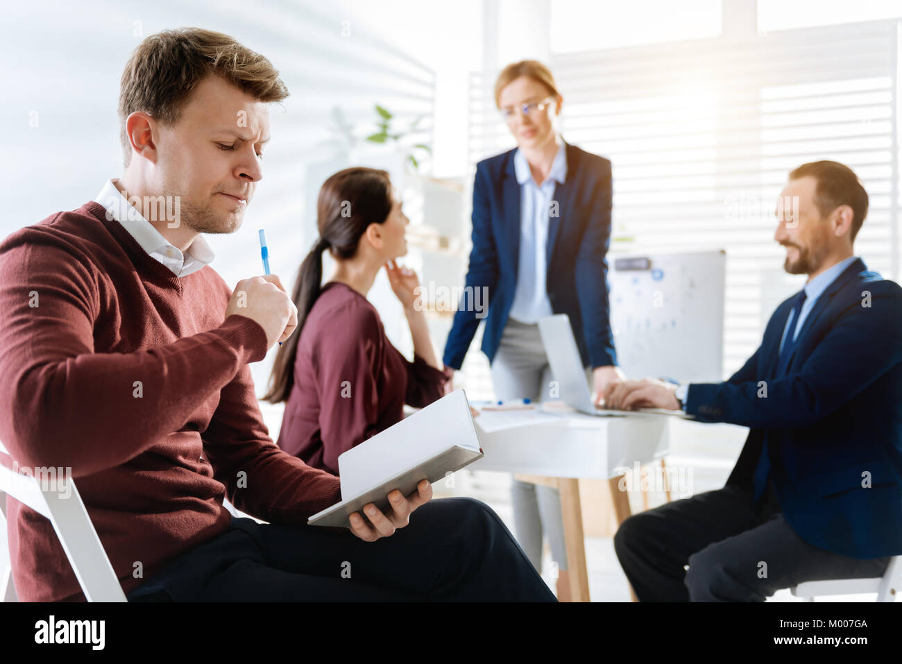 Meditative male colleague thinking hard Stock Photo - Alamy