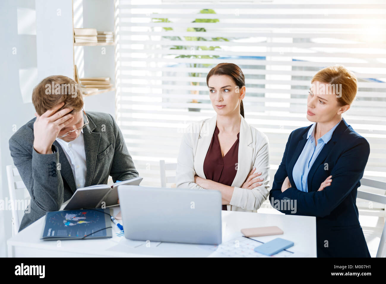 Concentrated three colleagues evaluating project Stock Photo - Alamy