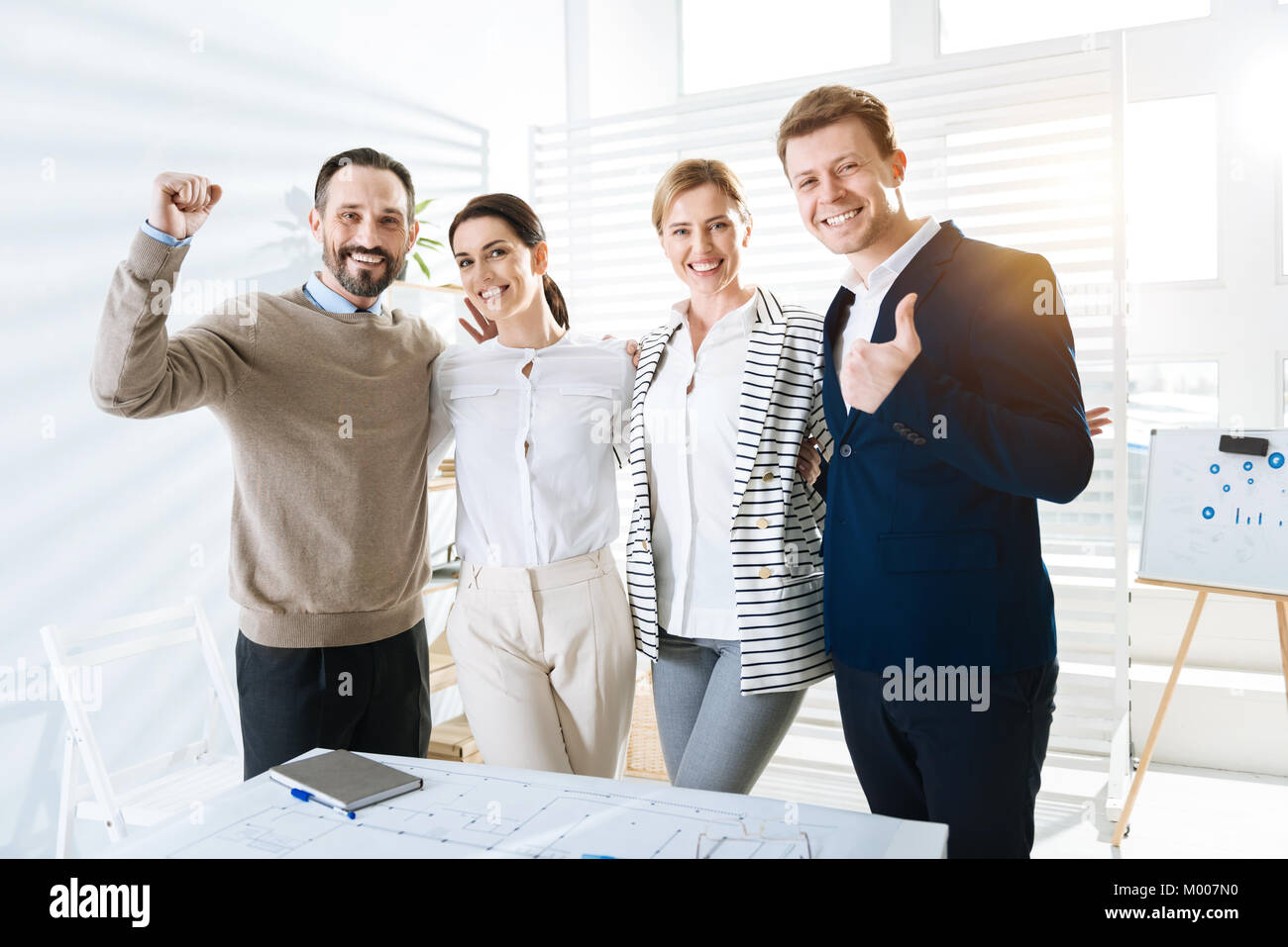 Vigorous four colleagues finishing working day Stock Photo - Alamy