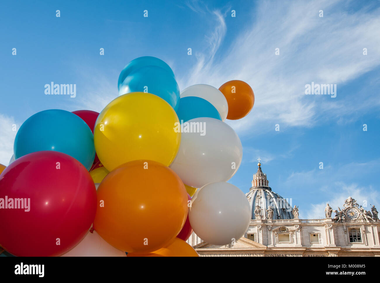 Colored balloons in front of the dome of St. Peter's Basilica during ...
