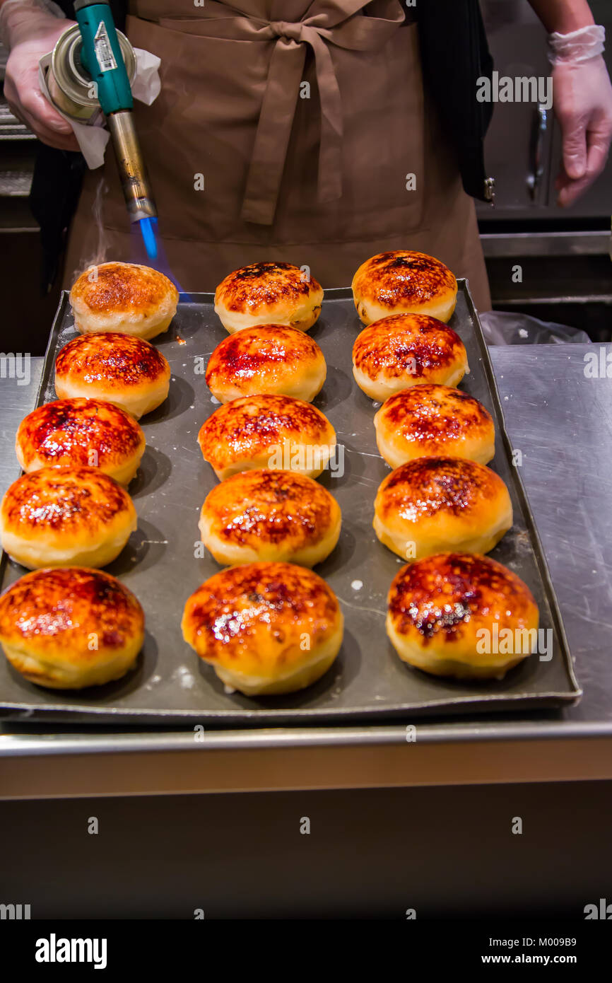 A pastry chef using a blow torch on his buns Stock Photo - Alamy