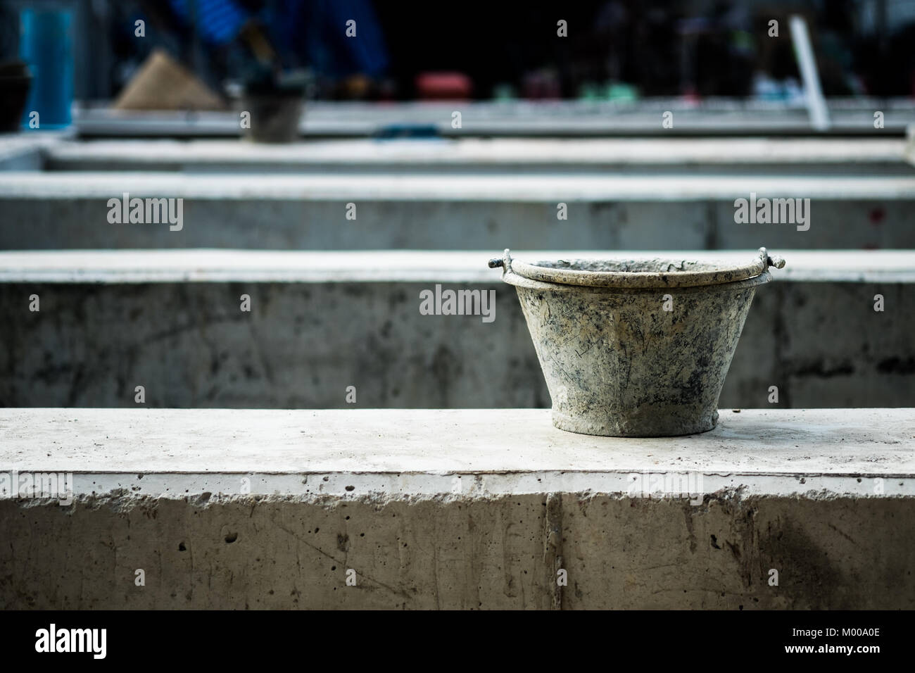Black plastic bucket filled with cement water stains. Placed on a large ...