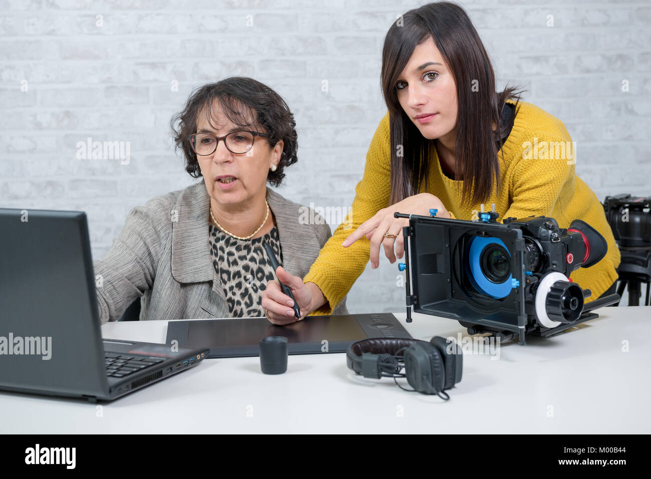 a woman video editor and young assistant using graphic tablet Stock ...