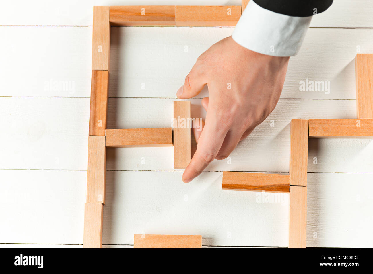 Man and wooden cubes on table. Management concept Stock Photo - Alamy