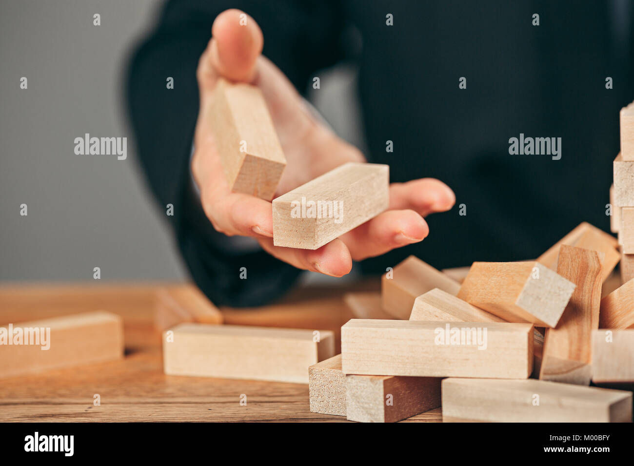 Man and wooden cubes on table. Management concept Stock Photo - Alamy