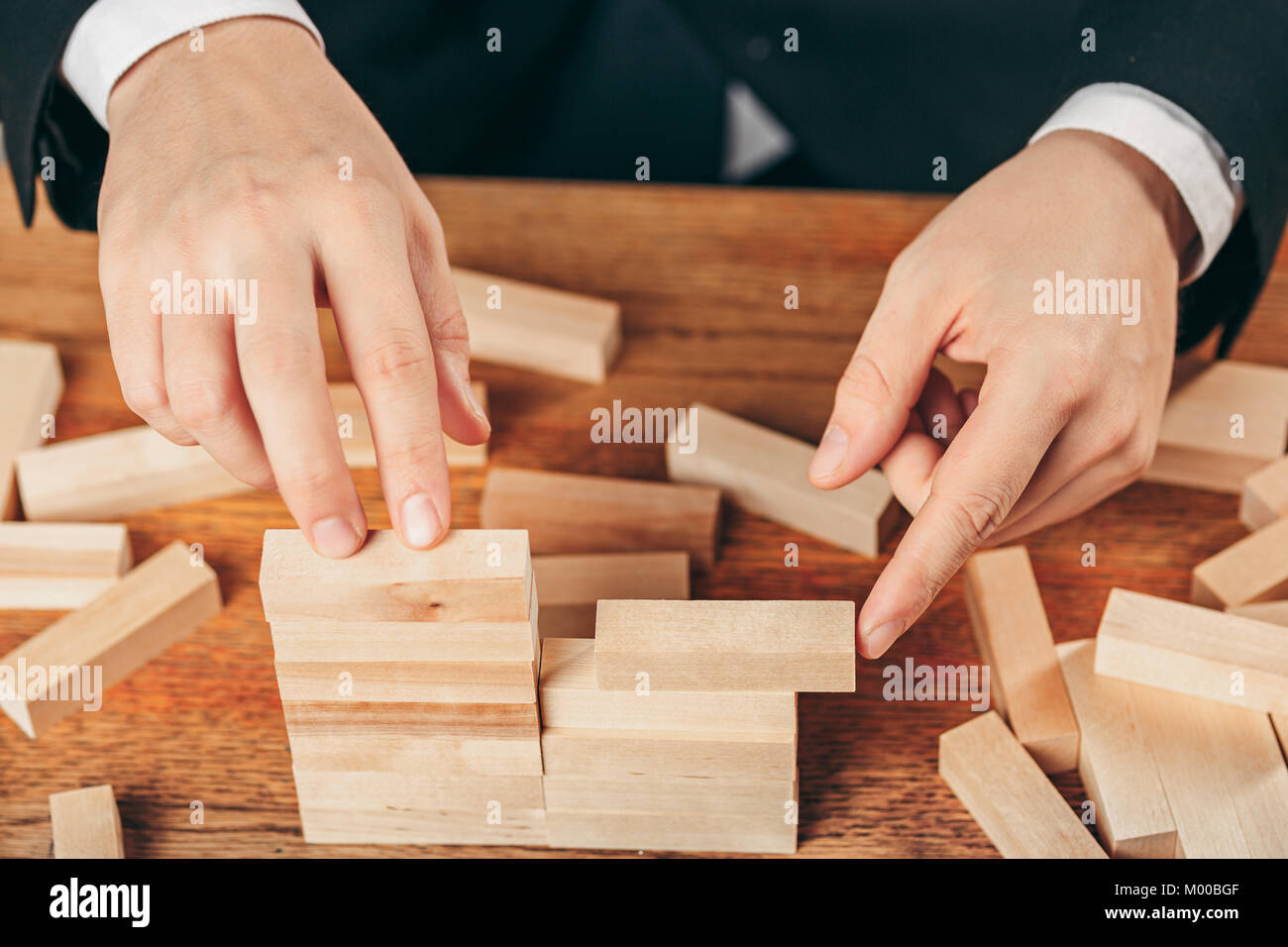 Man and wooden cubes on table. Management concept Stock Photo - Alamy