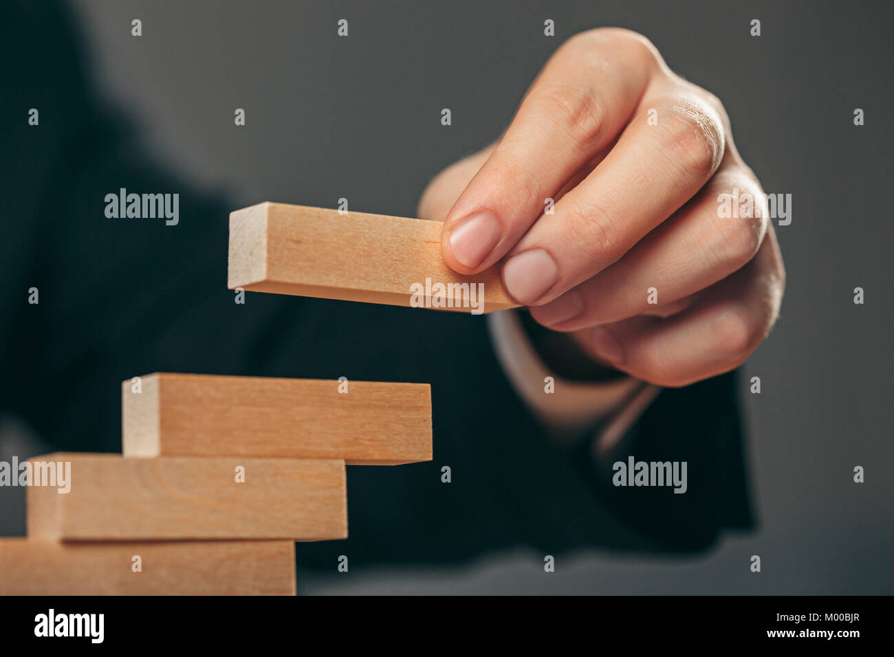 Man and wooden cubes on table. Management concept Stock Photo - Alamy
