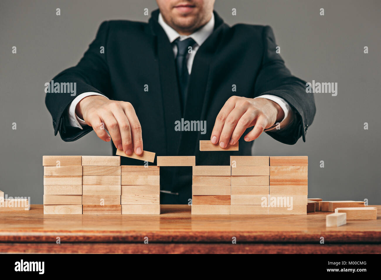 Man and wooden cubes on table. Management concept Stock Photo - Alamy
