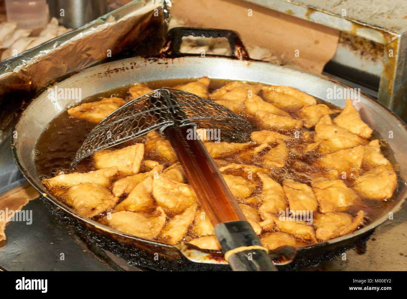 Samosas deep frying in an outdoor wok, Little India, Bangkok, Thailand ...