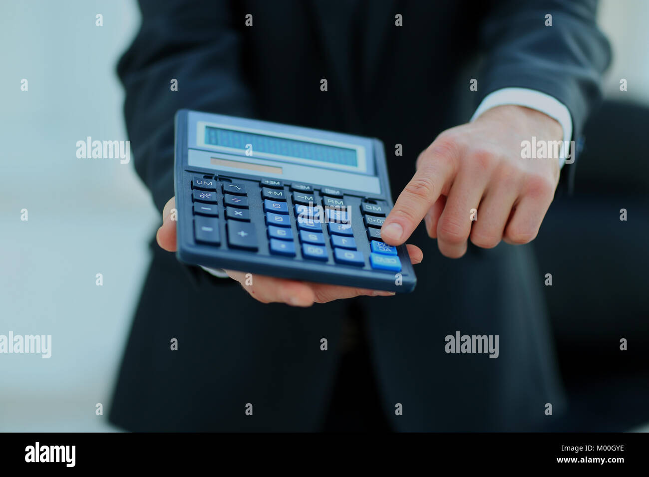 Businessman holding calculator Stock Photo - Alamy