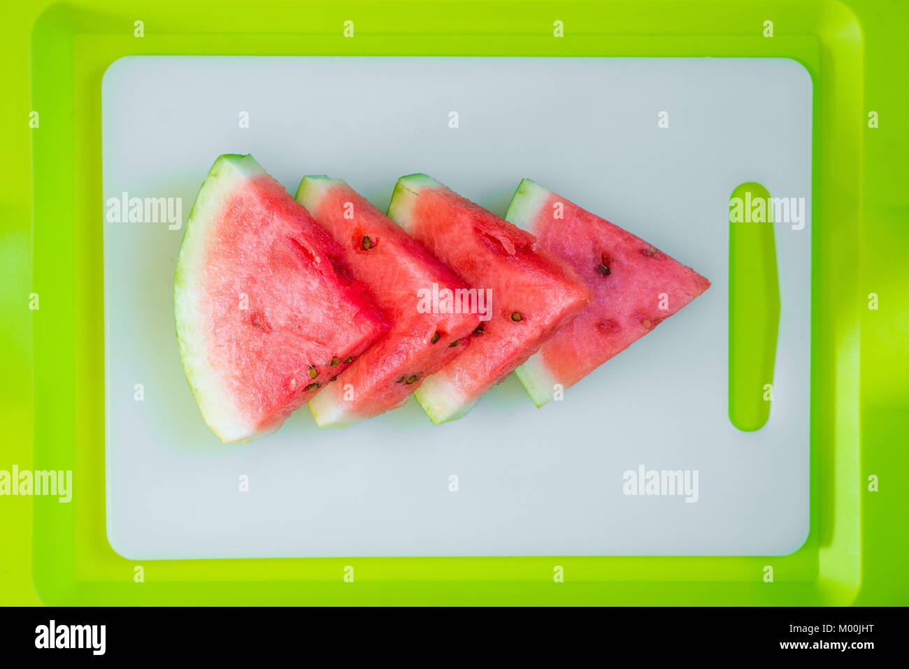 Fresh tasty watermelon in triangle slices on green background Stock ...