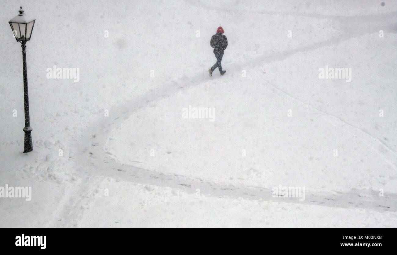 Irsee, Germany. 17th Jan, 2018. A man walks along an iced and snowy ...