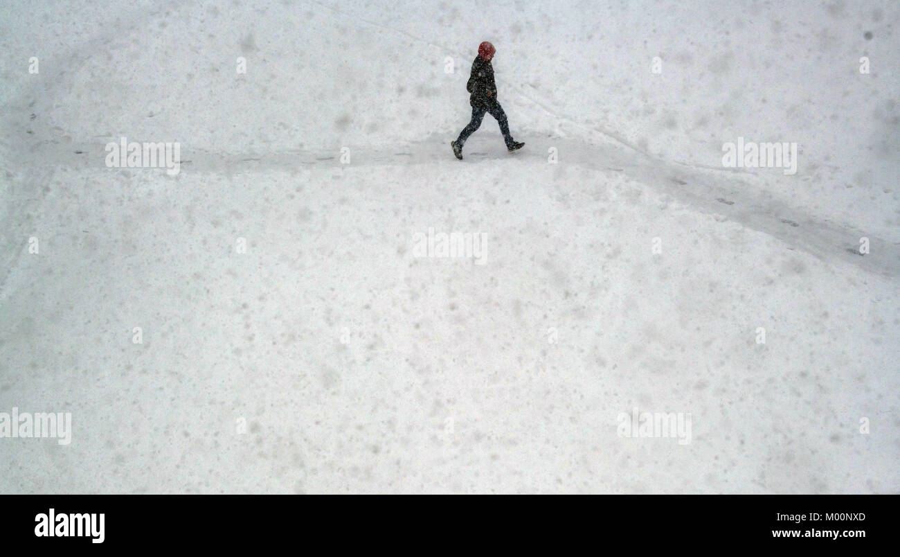 Irsee, Germany. 17th Jan, 2018. A man walks along an iced and snowy ...