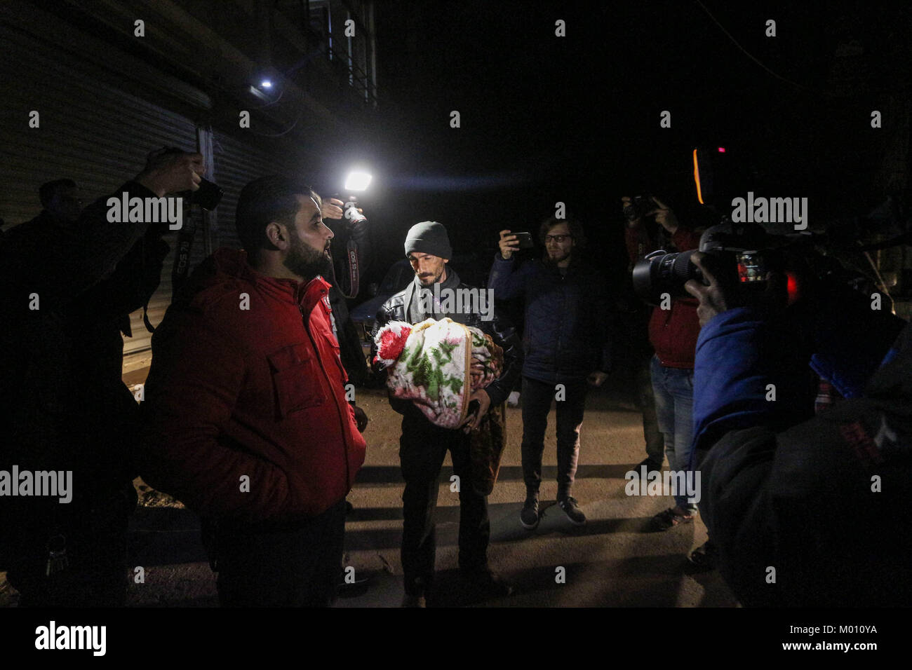 Douma, Syria. 17th Jan, 2018. A father seen carrying his son as he ...
