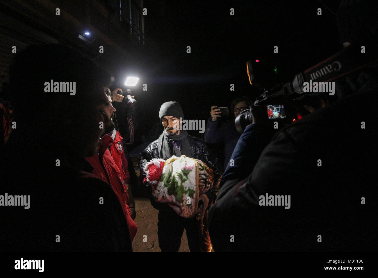 Douma, Syria. 17th Jan, 2018. A father seen carrying his son as he ...