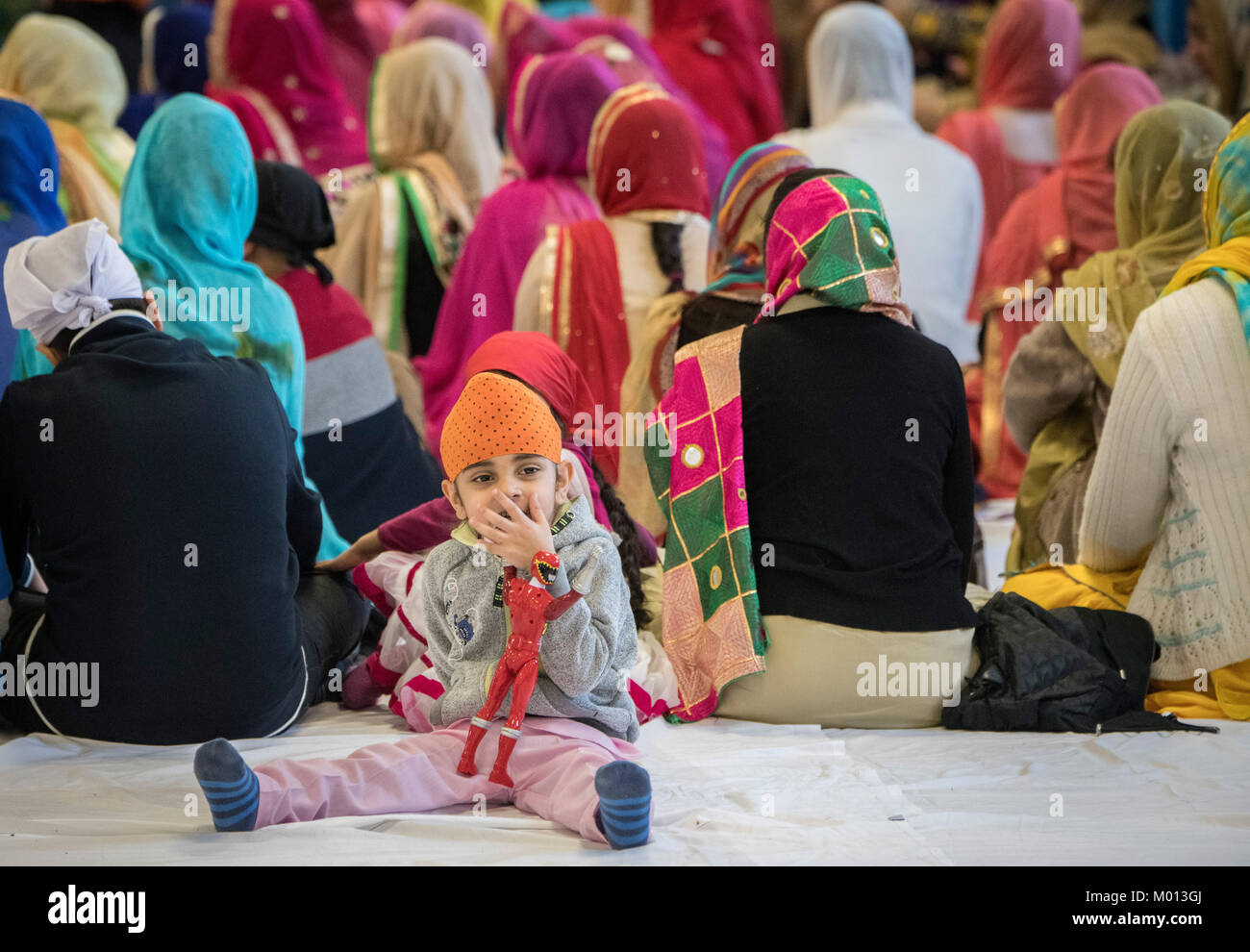 A little boy plays with his action figure while the adults around him ...