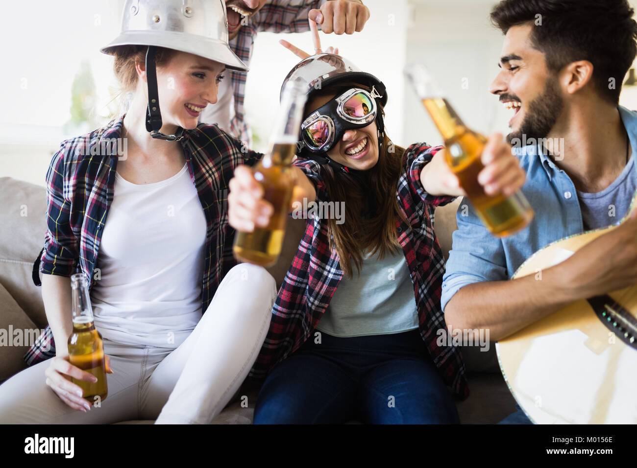 Cheerful friends having party and drinking beer Stock Photo - Alamy