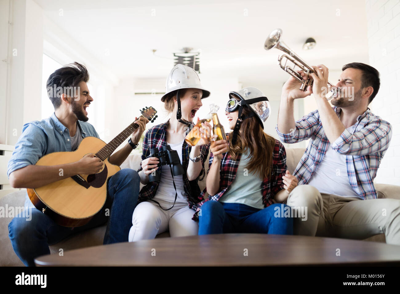 Cheerful friends having party together and playing instruments Stock ...