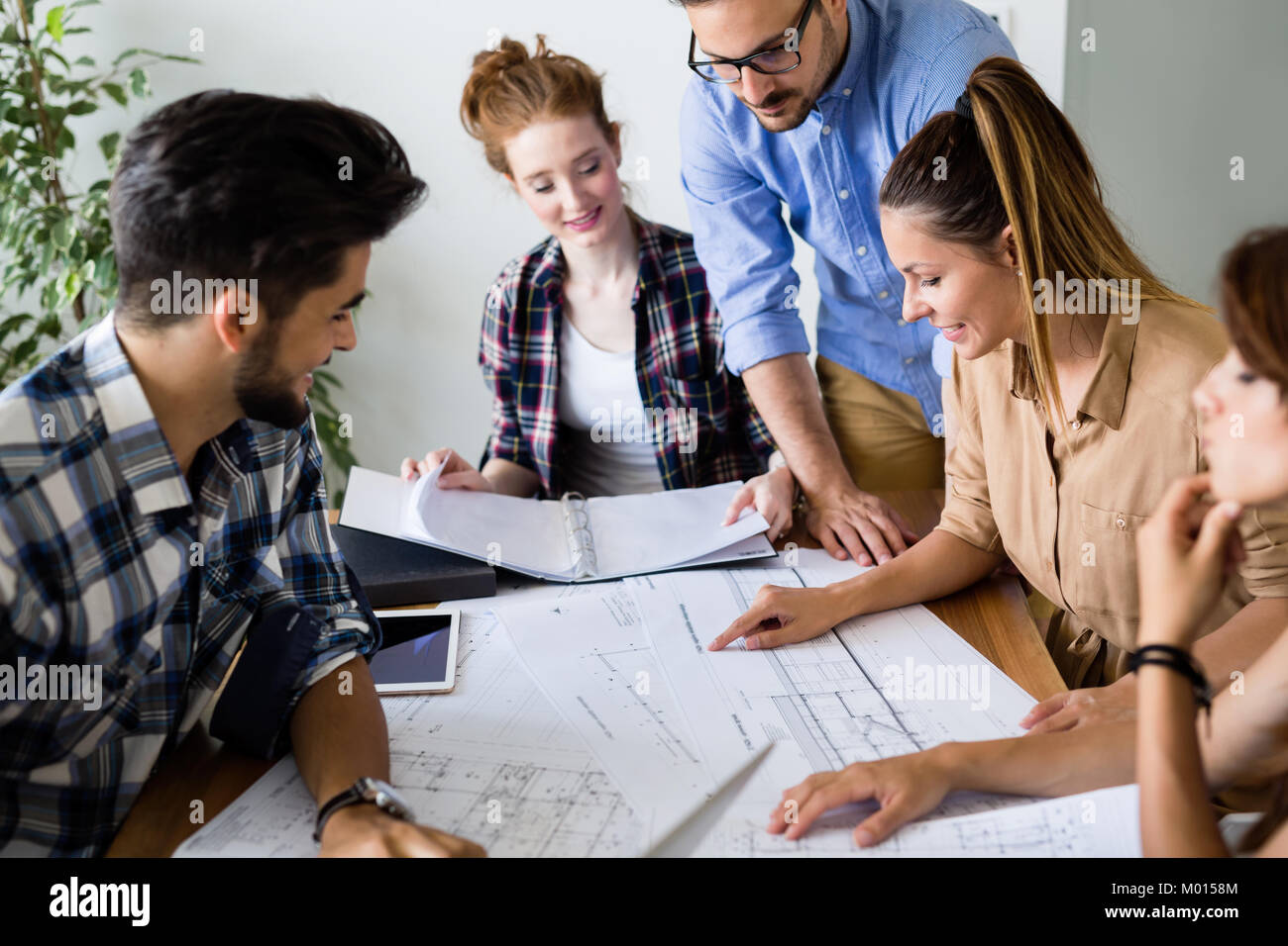 Group of architects and designers working and collaborating on project ...