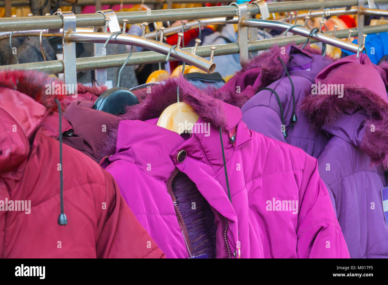 Fashion winter coats hanged on a clothes rack Stock Photo - Alamy