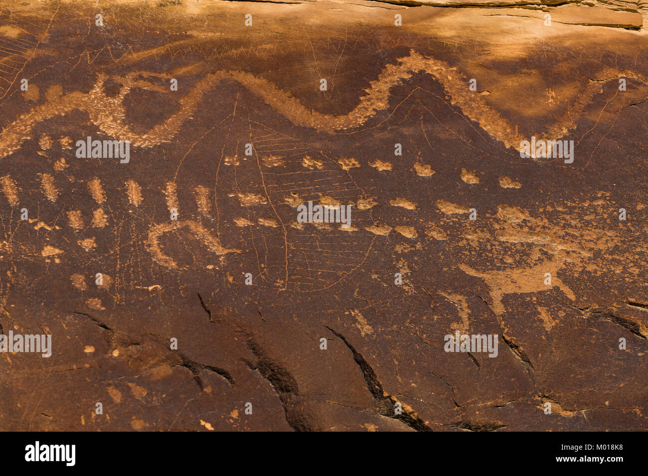 Petroglyph panel showing snake and animal, as well as dots and dashes ...