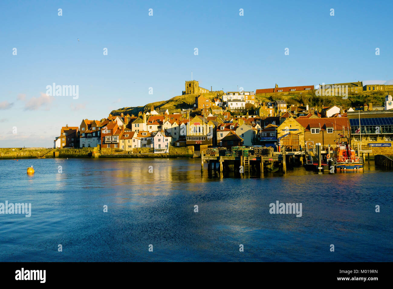 Whitby harbour with the lifeboat station and St Mary's church in winter ...