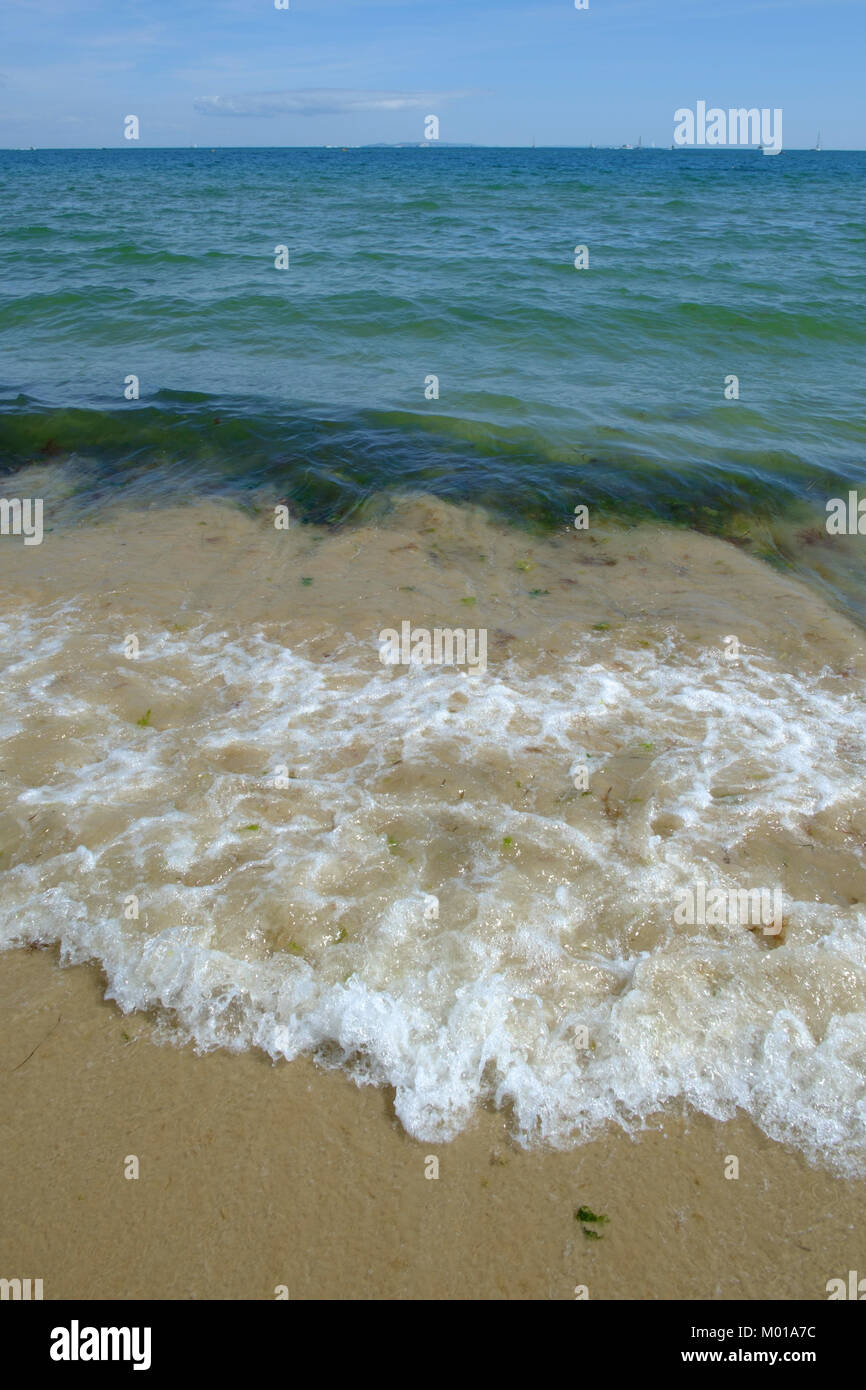 Wave crashing on to the beach Stock Photo - Alamy