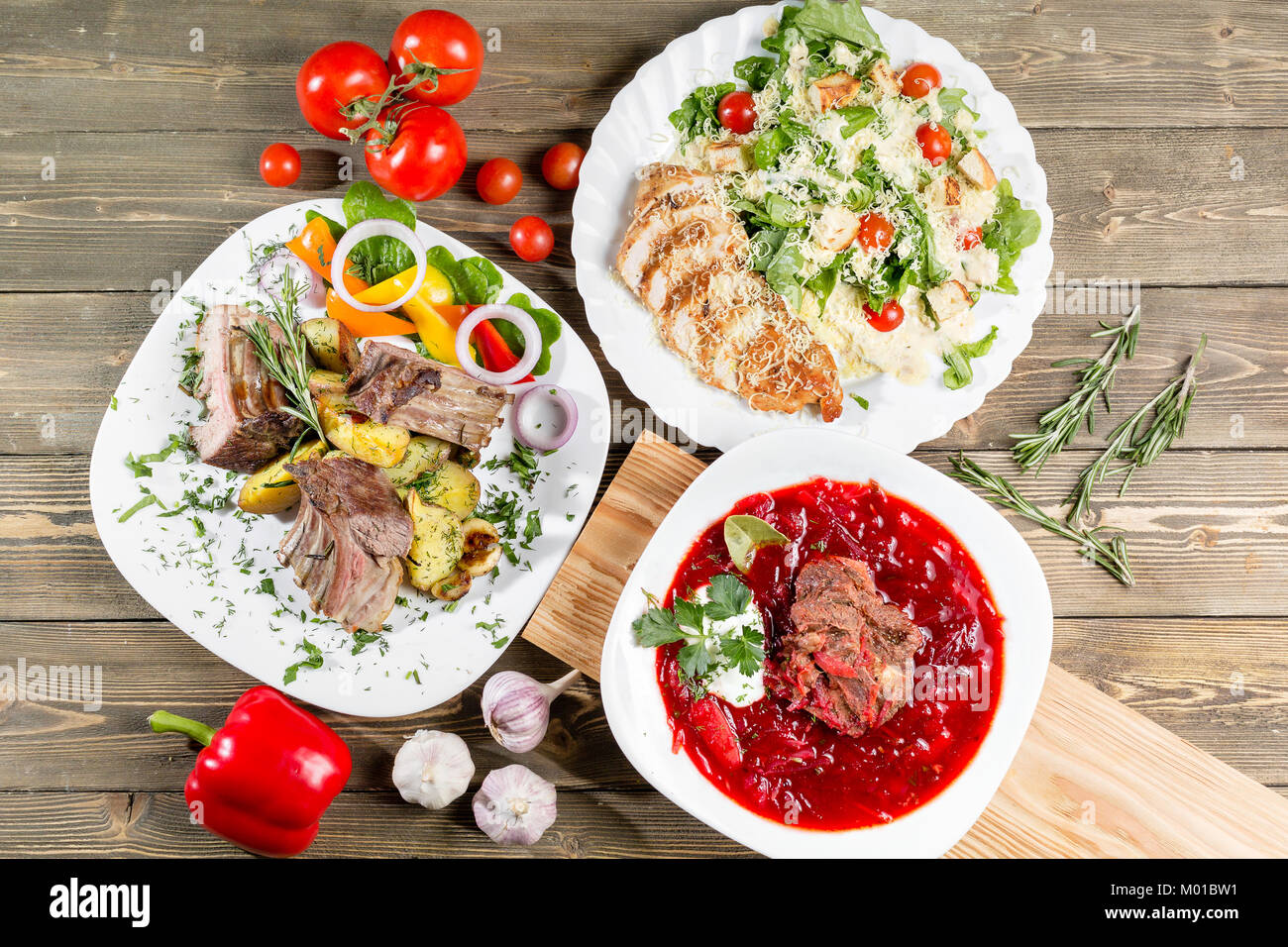 Different dishes on wooden table, top view. Vegetable beet soup, rack ...