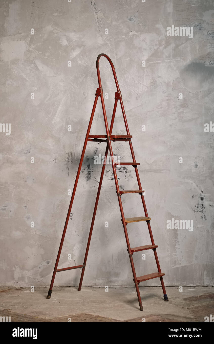 Used metal ladder near concrete wall Stock Photo - Alamy