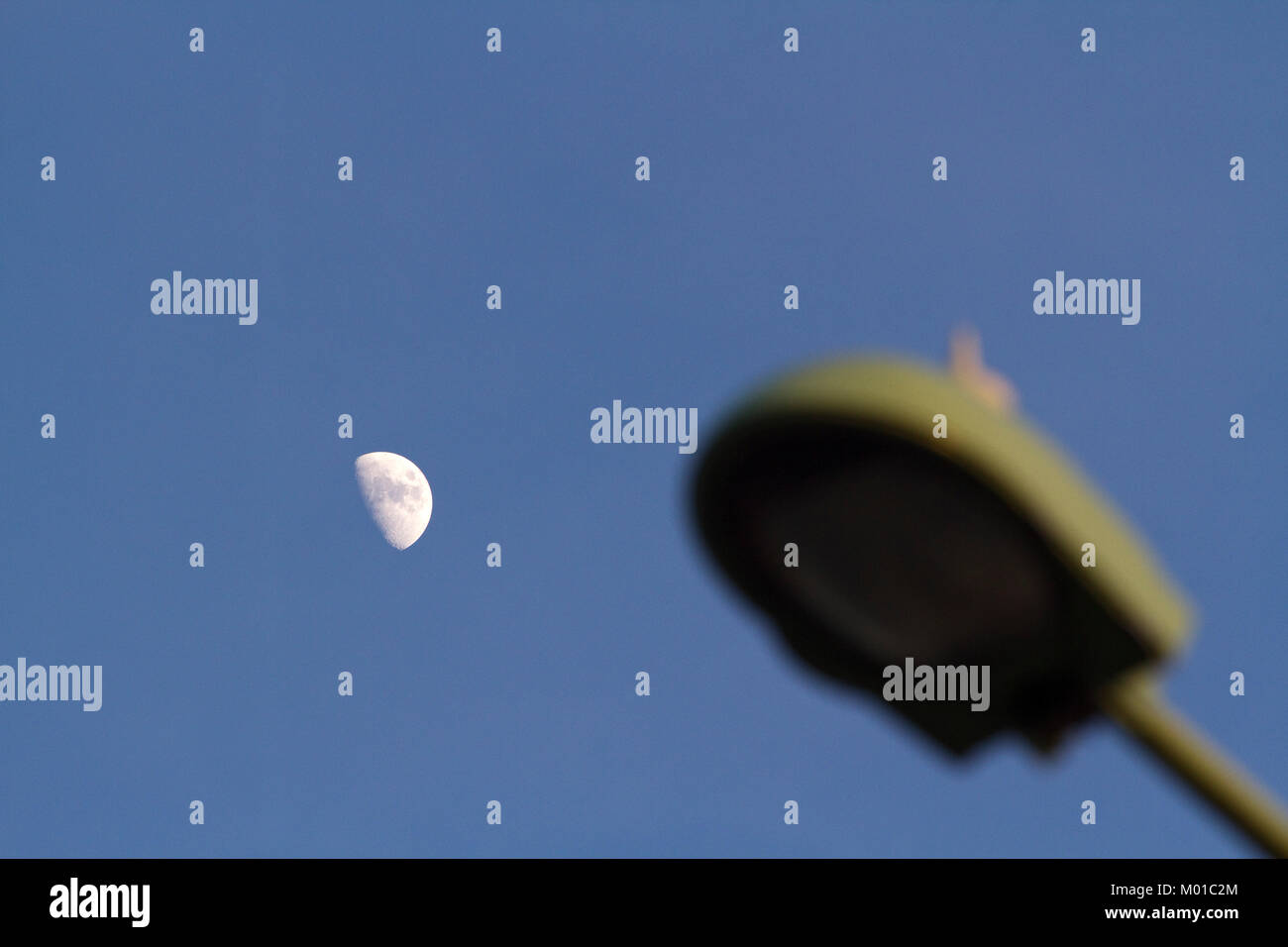 The oddity of a day time moon against an out of focus street light ...