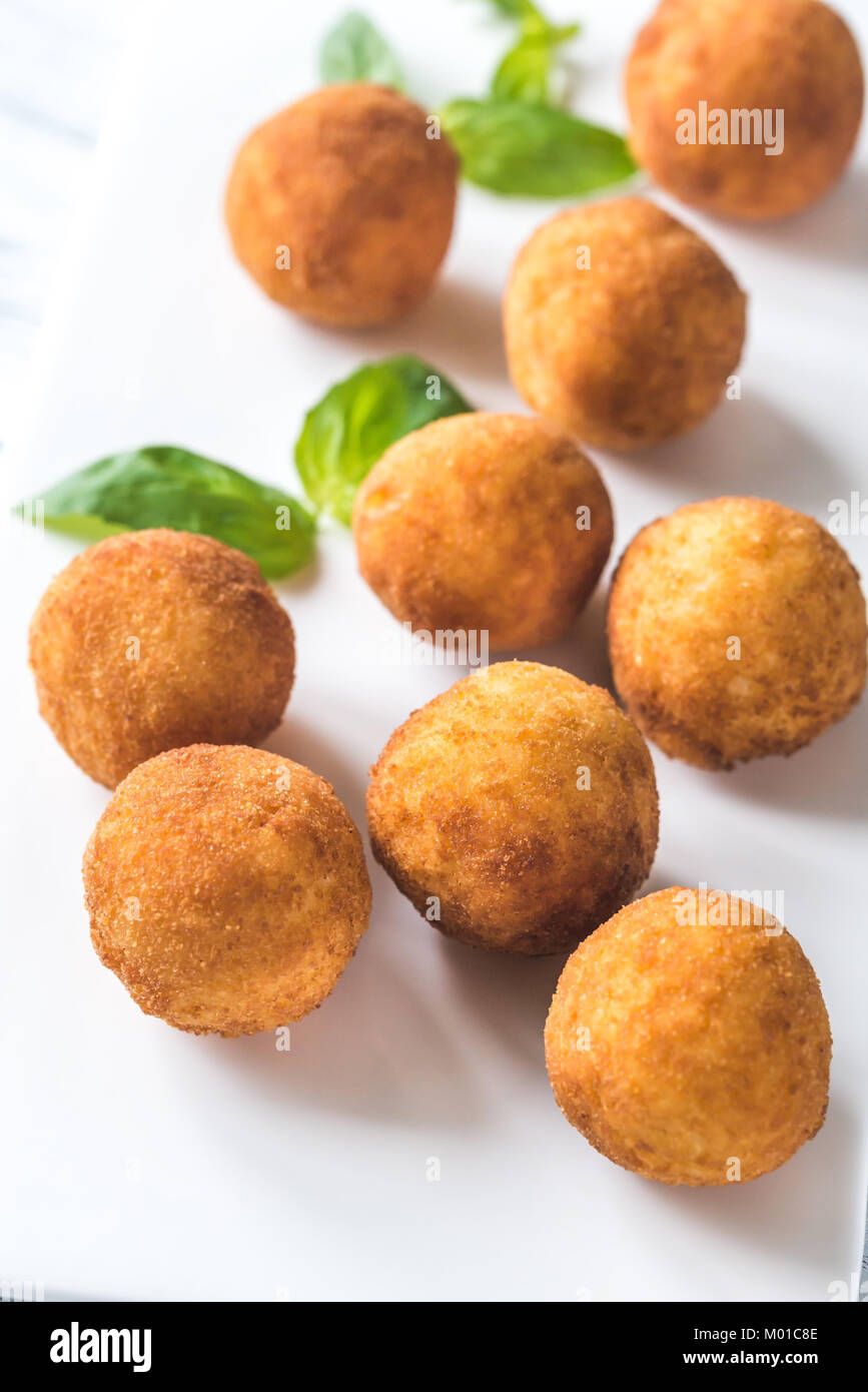 Homemade fried Arancini with basil on a rustic wooden board, side view ...