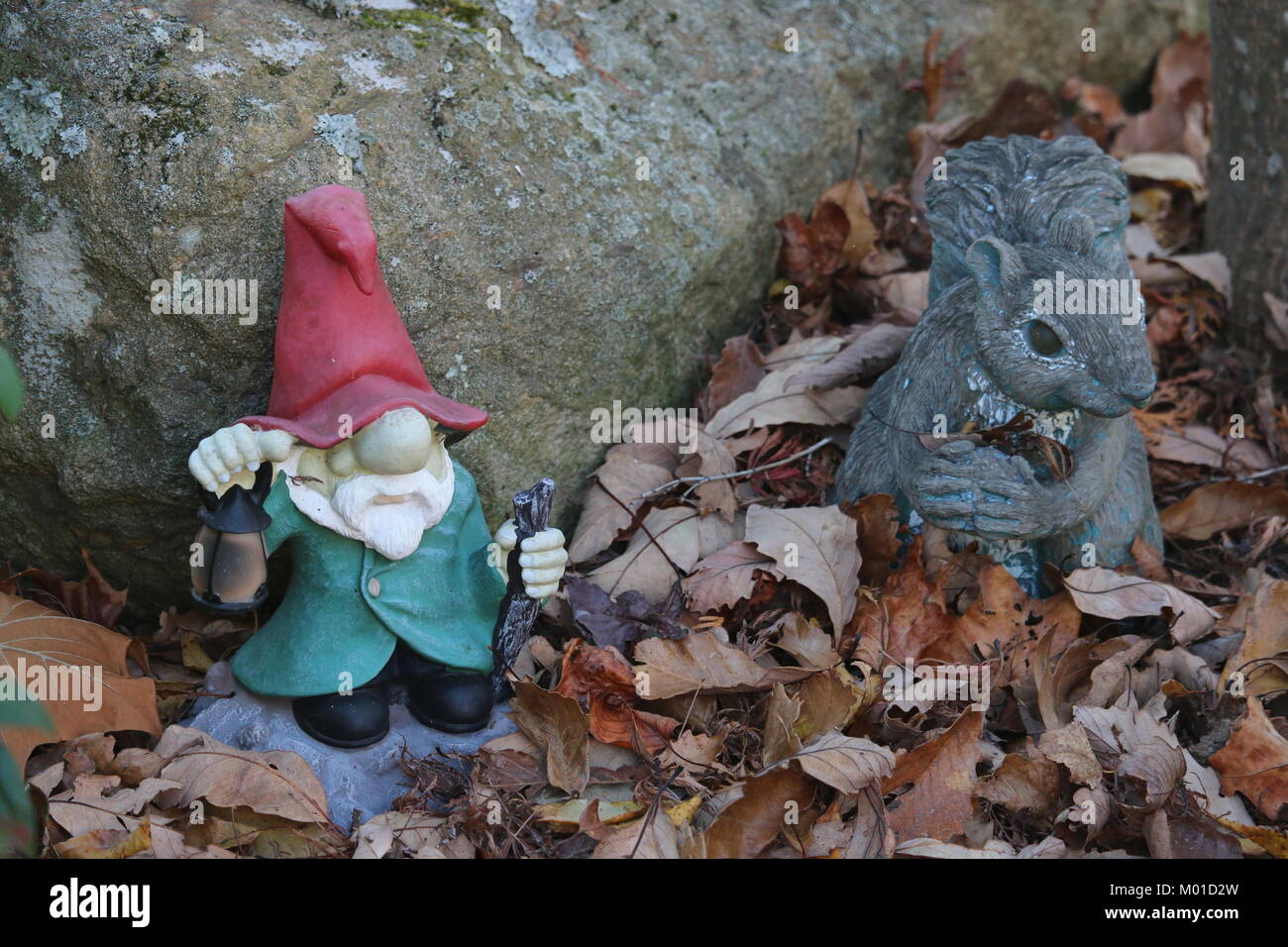 Gnome and Squirrel statues in garden Stock Photo - Alamy
