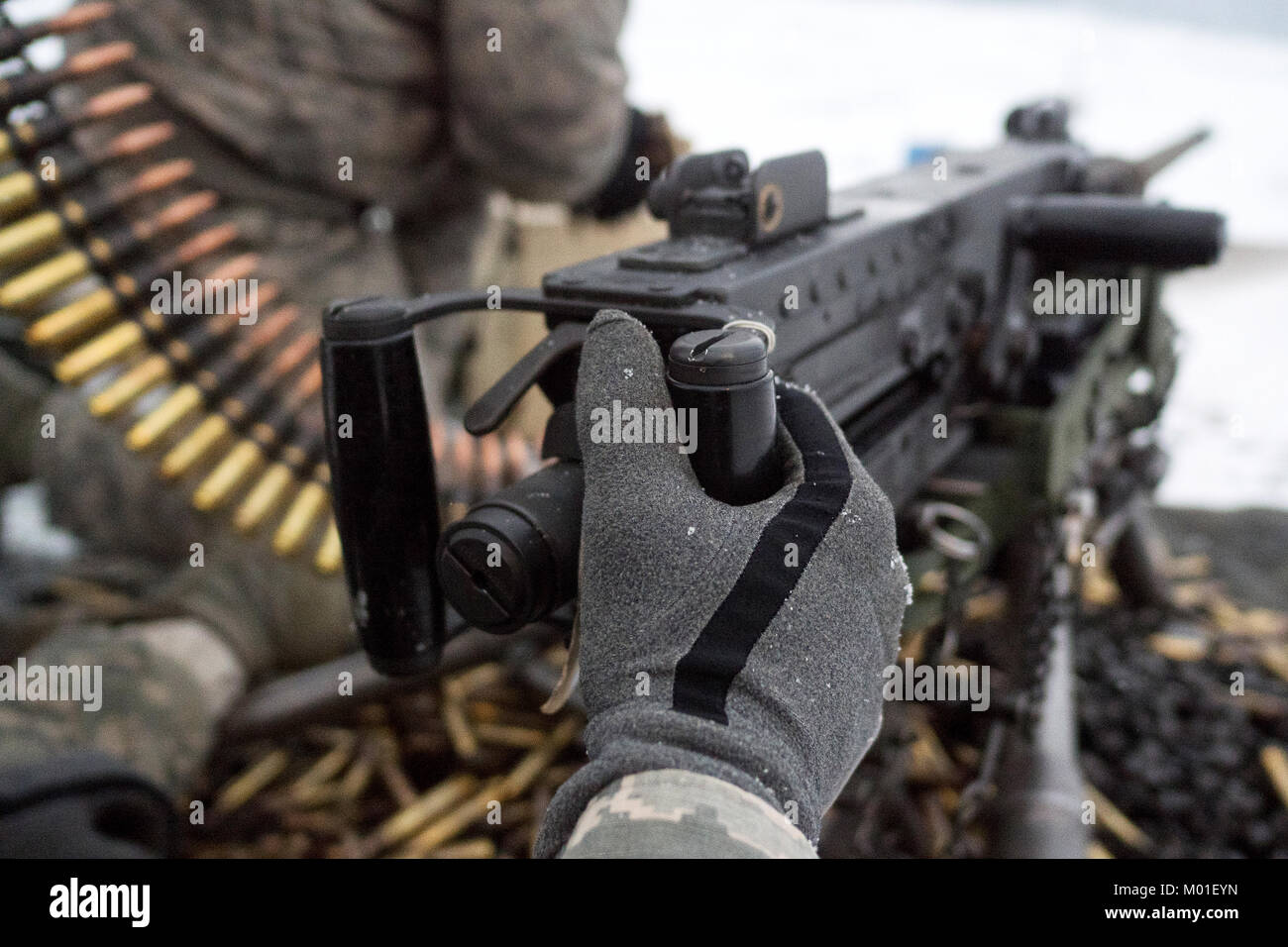 Airmen assigned to the 673d Security Forces Squadron load an M2 .50 ...
