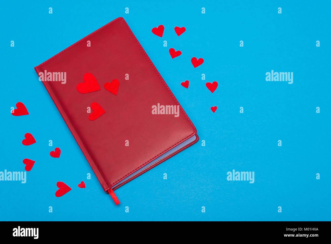 Diary lying on a blue background with hearts Stock Photo - Alamy