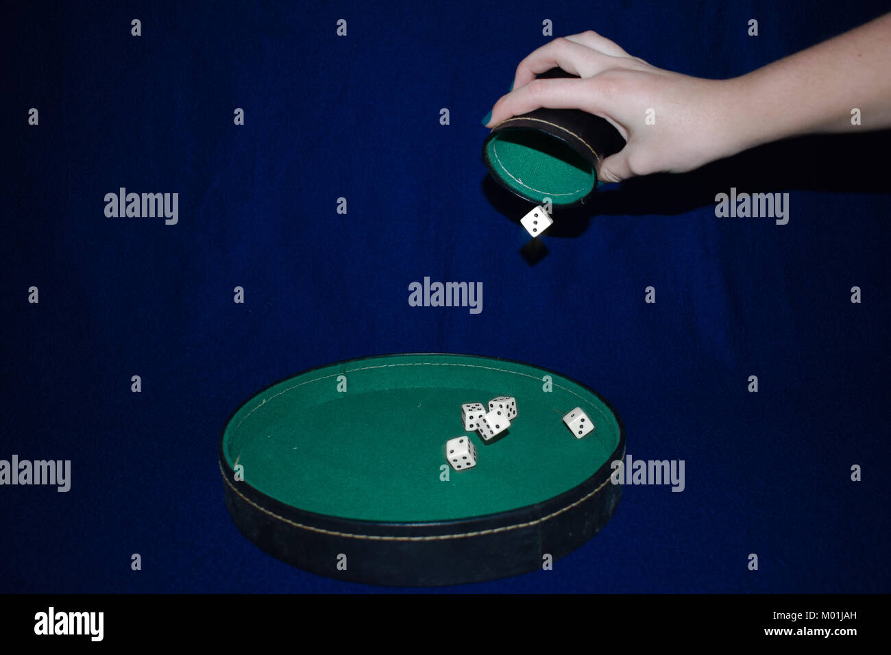 Hand Rolling Dice On Table