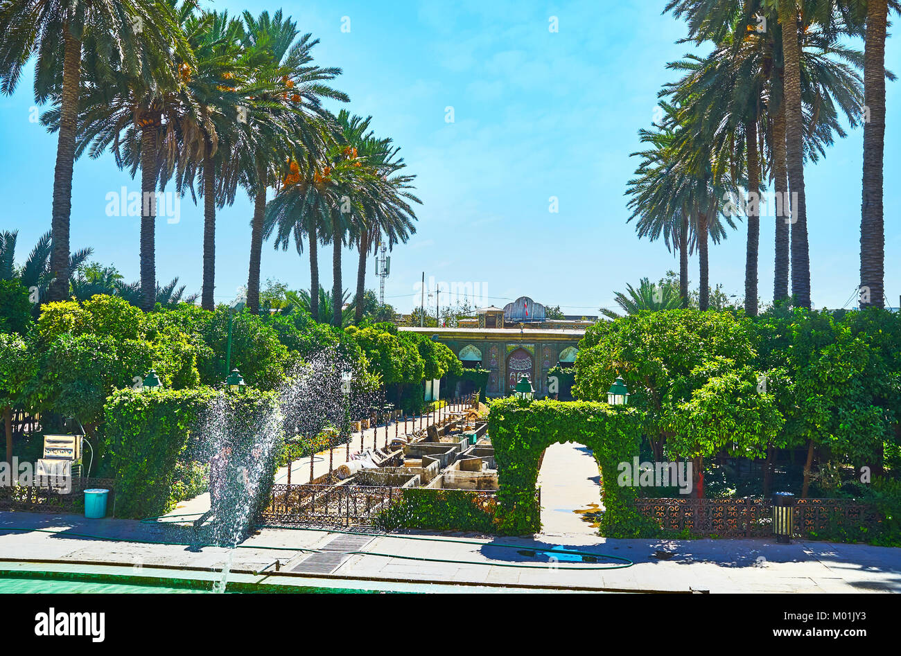 The lush garden of Naranjestan complex with shady trees, tall palms ...