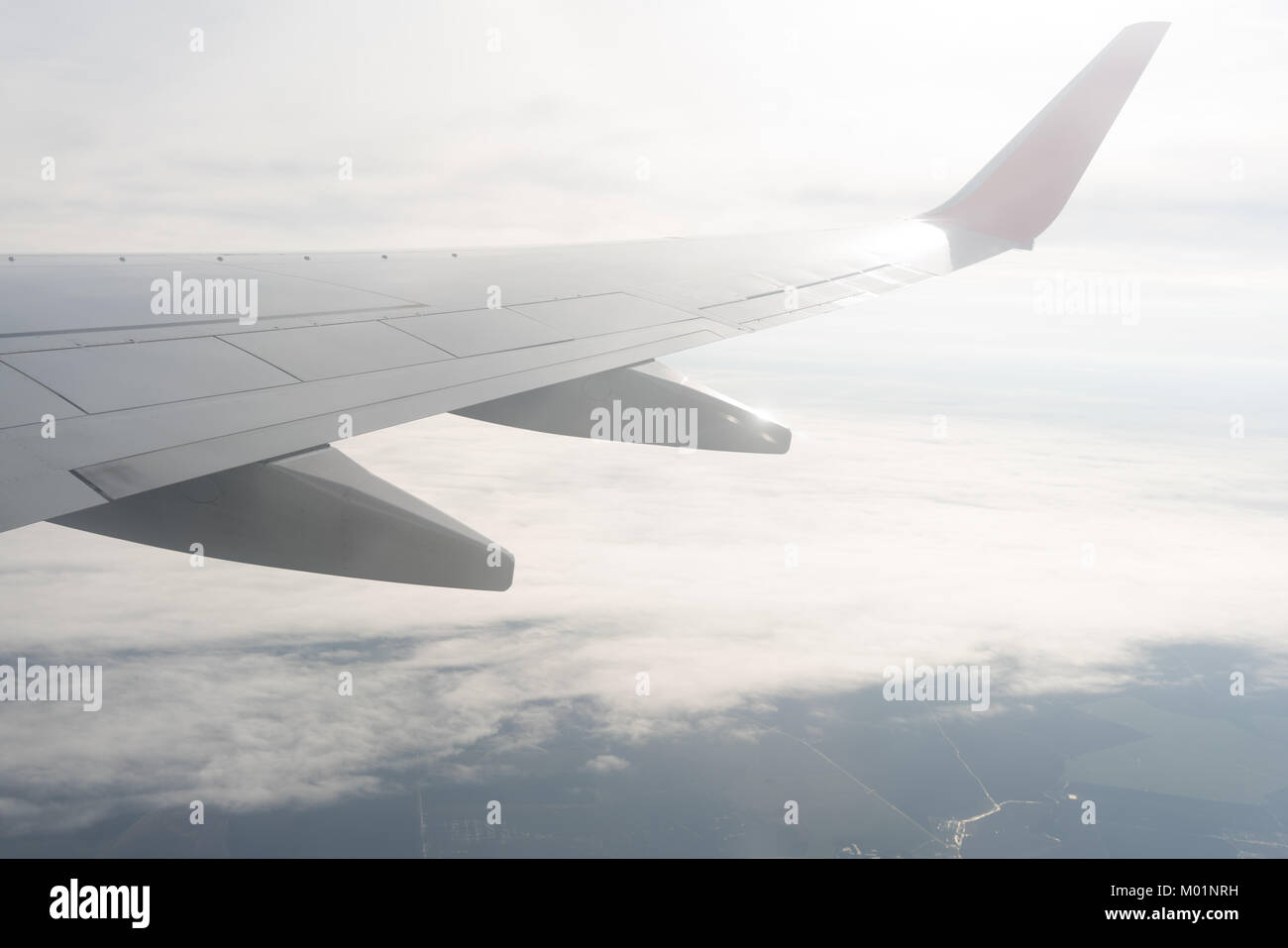 Airplane wing with sunrise in light flare Stock Photo - Alamy