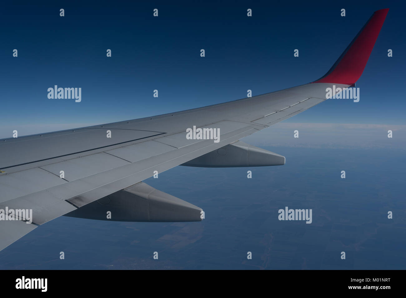 Airplane wing with sunrise in light flare Stock Photo - Alamy